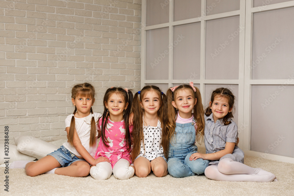 Group of kid sitting on floor together. four little girls have fun ...