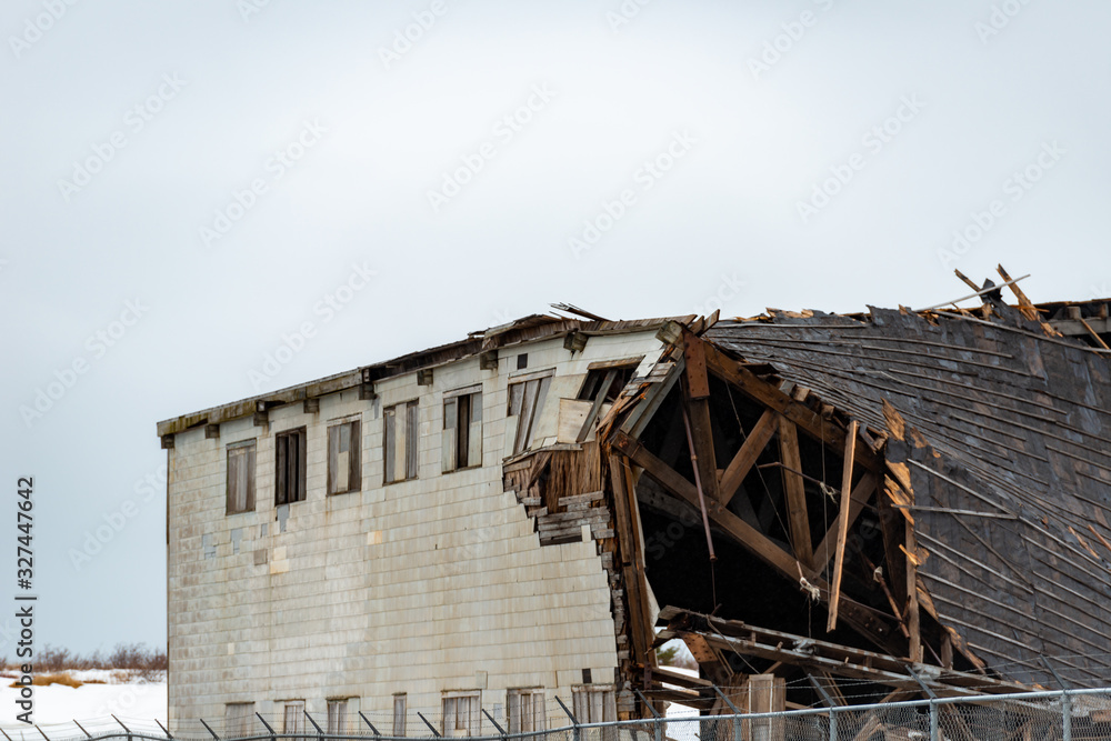 An old and dilapidated concrete building with broken windows on the top ...