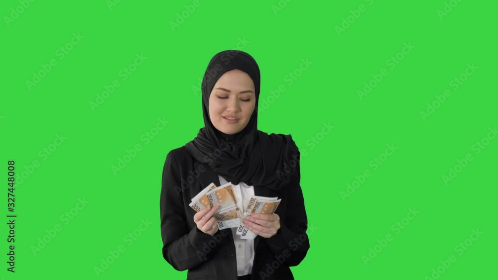 Pretty woman in hijab walking and counting money on a Green Screen ...