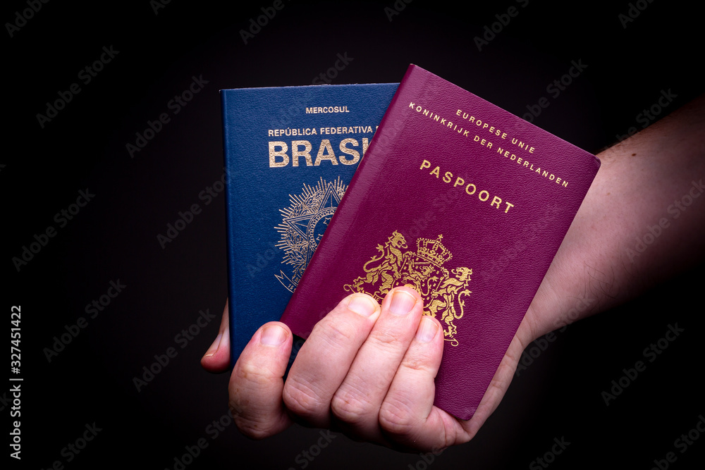 Hand holding two passports, Brazilian and European -Dutch- passport ...