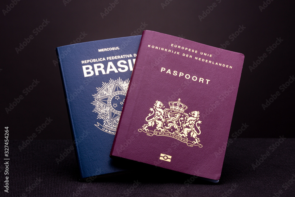 European - Dutch - passport in front of a Brazilian passport on a dark ...