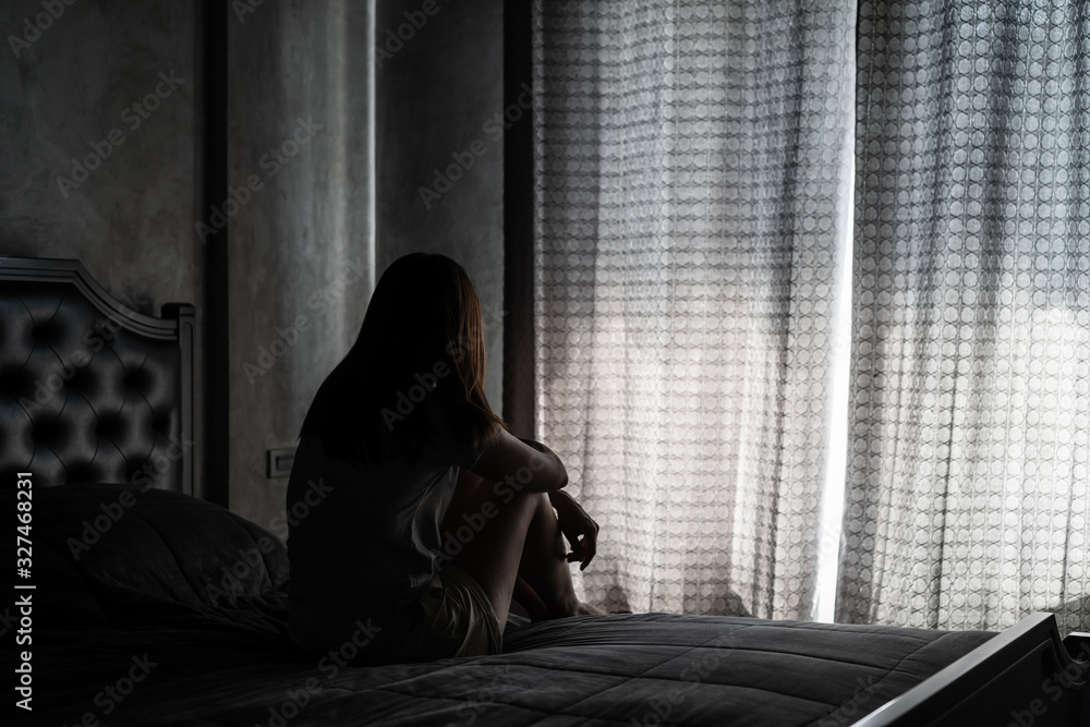 Lonely young woman feeling depressed and stressed sitting head in hands ...
