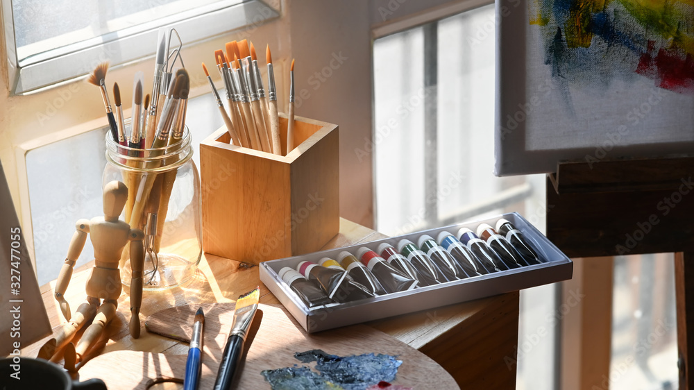 Photo of artist equipment putting on wooden working table. Paint brush ...