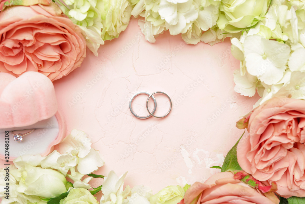 Beautiful wedding rings with flowers on color background Stock Photo ...