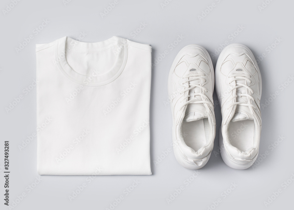 Fashion female clothes on white background. Basic T shirt and sneakers ...