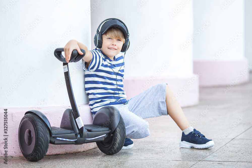 Cute child driving electric gadget. Boy riding a segway. Active child ...