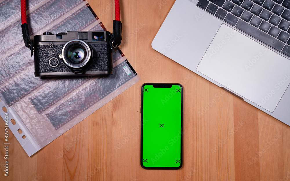 smartphone on a desktop background with a book and a film camera work ...