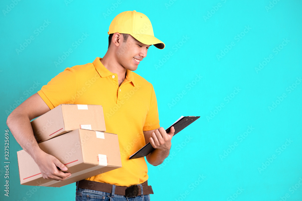 Happy delivery man in yellow polo shirt uniform holding parcel post box ...