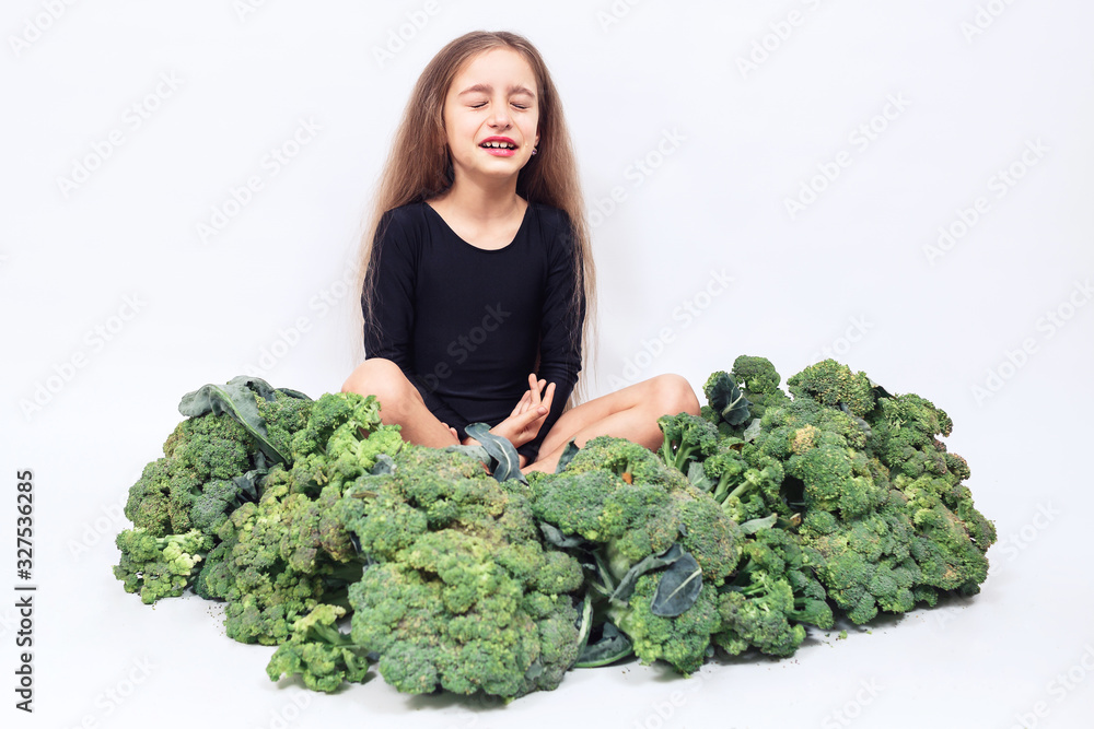 little girl sits in pile of broccoli and cries. child does not like to ...
