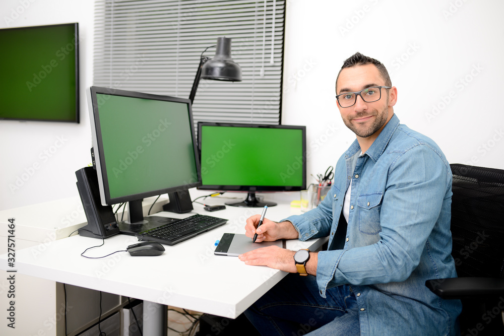 handsome young man graphic artist working in office desk with a ...