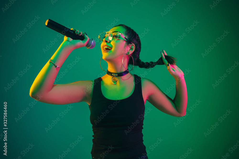 Caucasian female singer portrait isolated on green studio background in ...