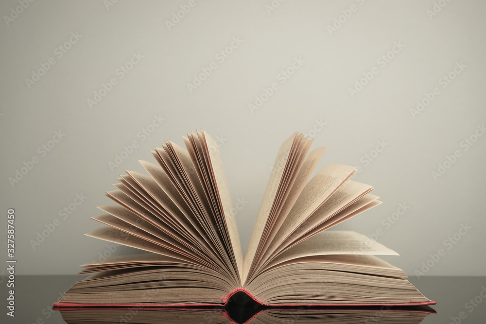 Beautiful open book on a gray and glass table background. Stock Photo ...