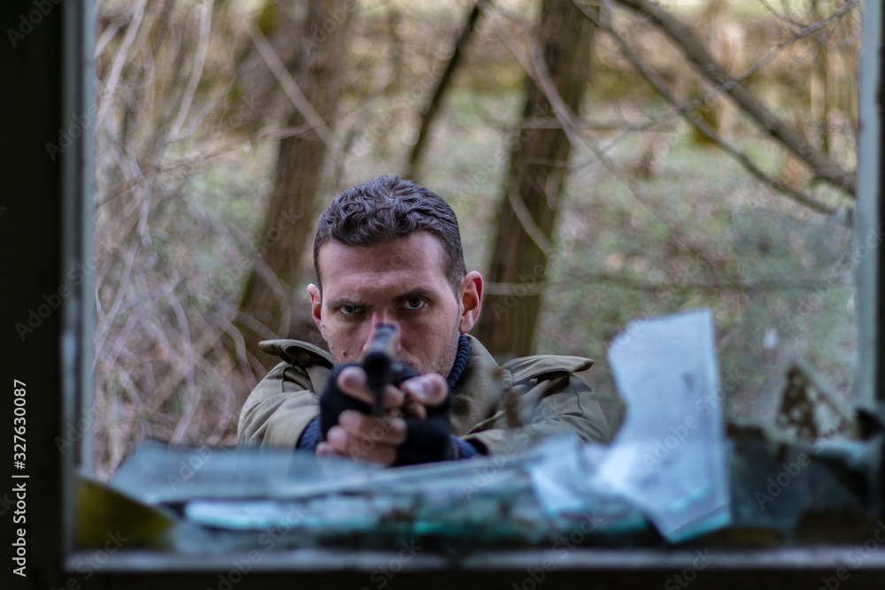 Soldier pointing a gun trough a broken window with no helmet Stock ...