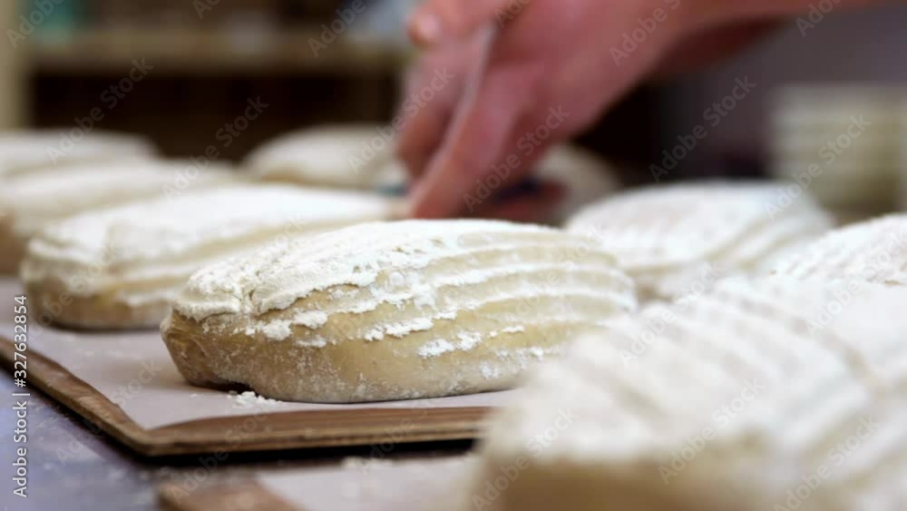 baker scoring proofed bread dough for the oven, close Stock Video ...
