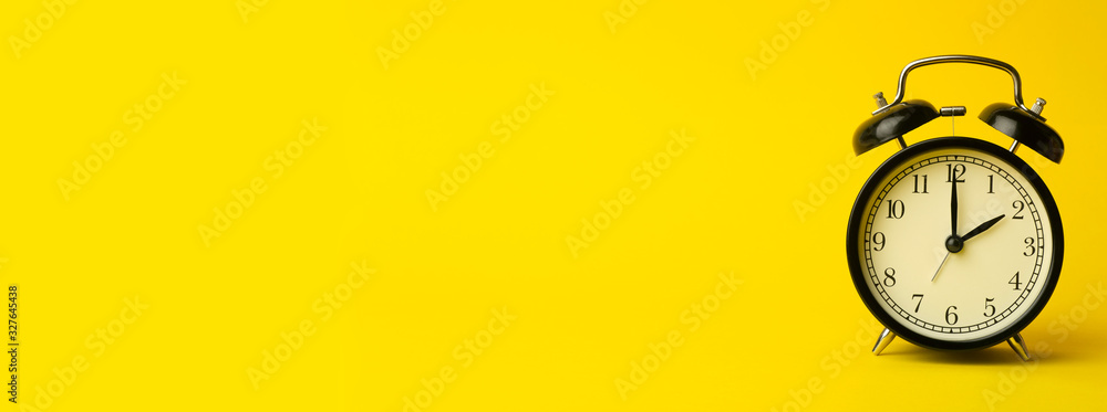 Time background concept. Vintage classic alarm clock on yellow empty ...