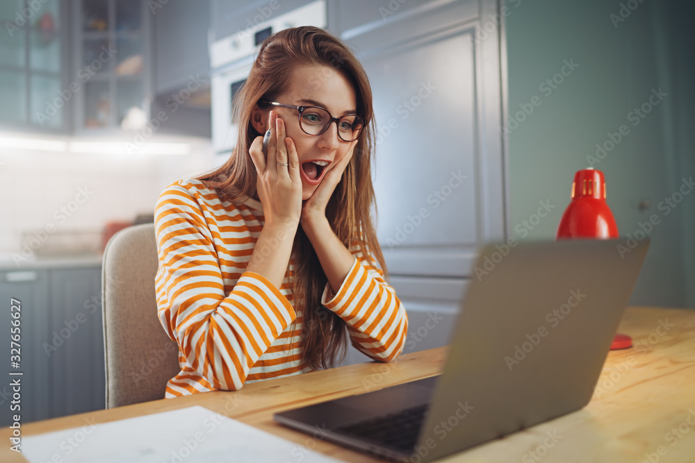 Winning success woman screaming of joy while sitting with laptop at ...