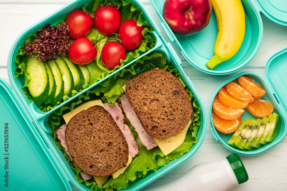 Top view of school lunch boxes with sandwiches and vegetables with ...