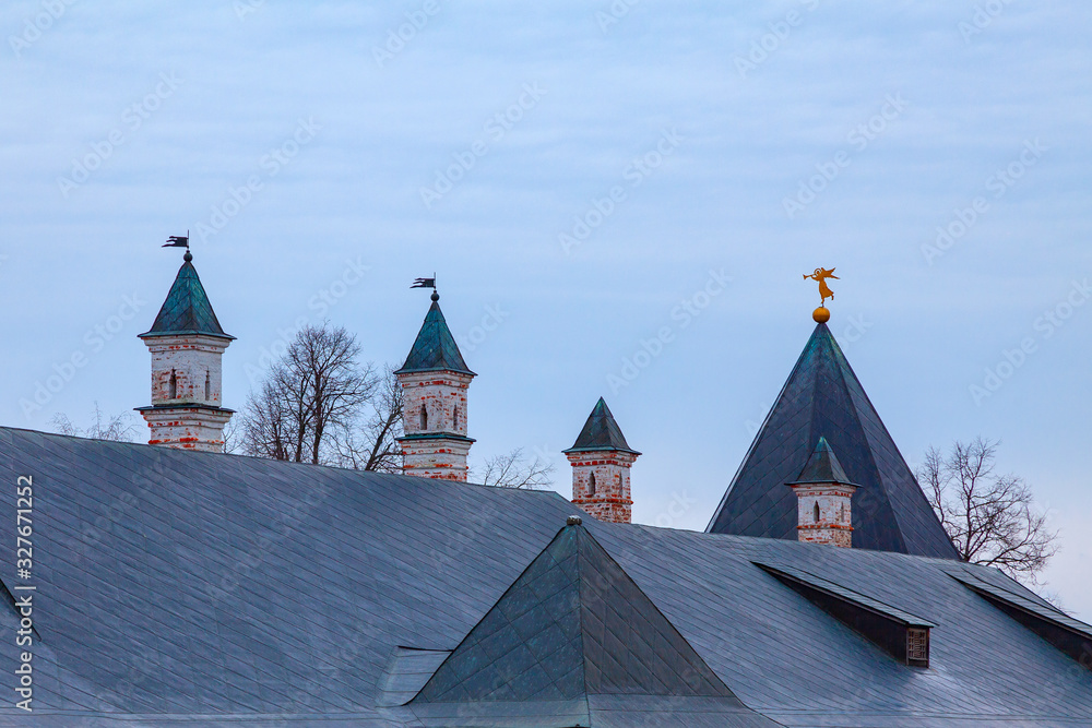 Turrets of various heights with metal flags on the roof of the ...