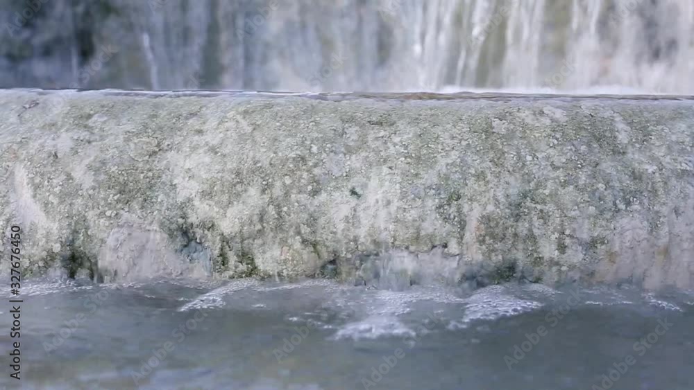 Hot spring water running fast over rocks and collecting in pools ...