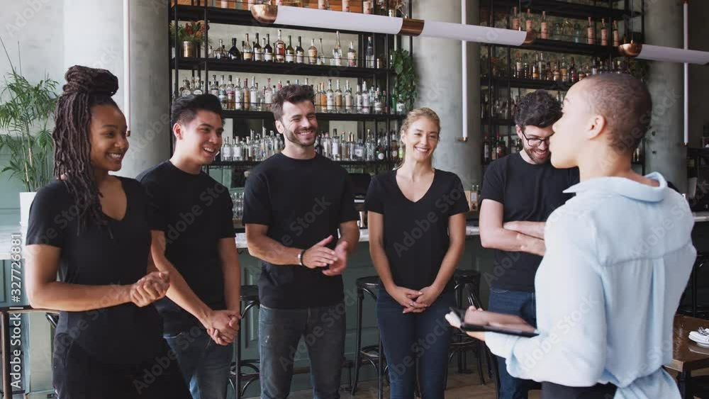 Female restaurant bar manager holding digital tablet giving ...