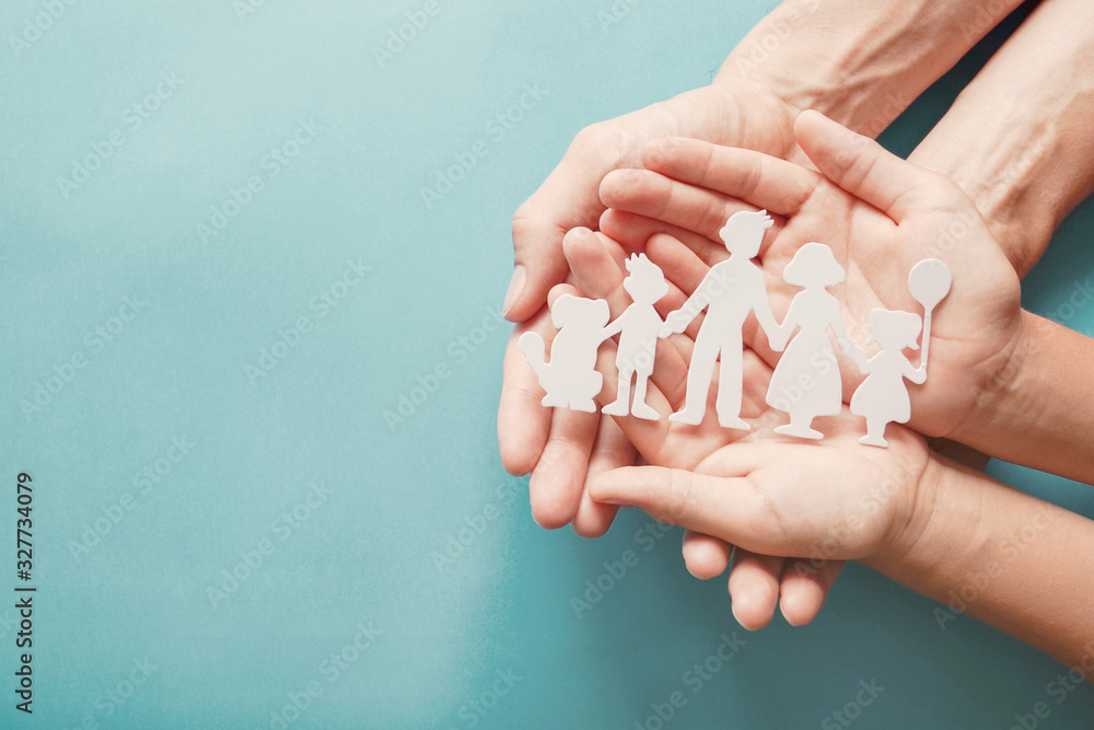 Adult and children hands holding paper family cutout, family home ...