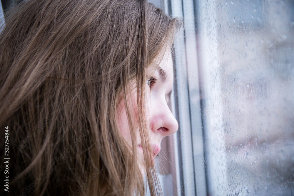 Close up face of teenage girl. The girl clung to the window with ...