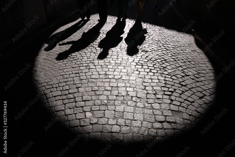 four shadows of men on the road made of volcanic cobblestones called ...
