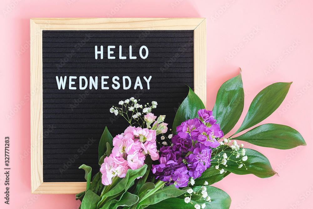 Hello Wednesday text on black letter board and bouquet colorful flowers ...