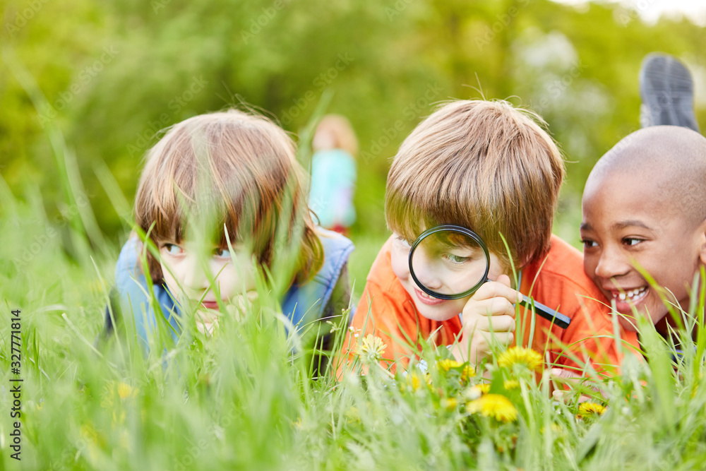 Drei Kinder erforschen Natur mit der Lupe Stock Photo | Adobe Stock