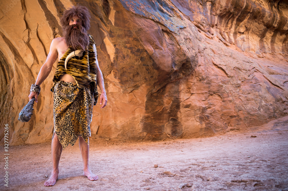Caveman standing outdoors holding his club in an empty cave Stock Photo ...