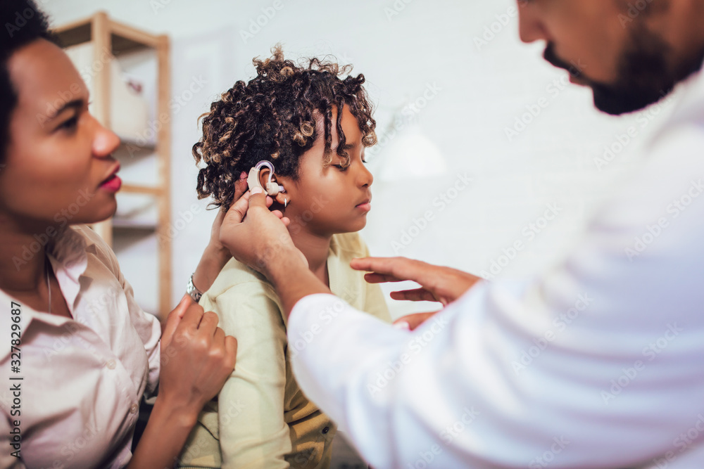 Smiling deaf girl with ear implant at doctor's office. Stock Photo ...