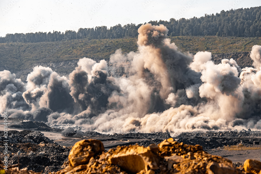 Explosive works on open pit coal mine industry with dust and puffs of ...
