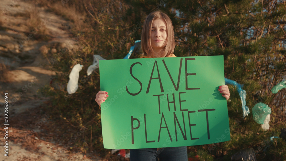 Portrait young woman activist holding encouraging green poster Save the ...