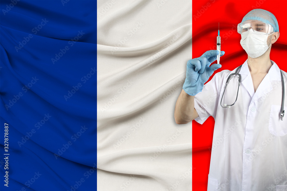 doctor with stethoscope against backdrop of the silk national flag of ...