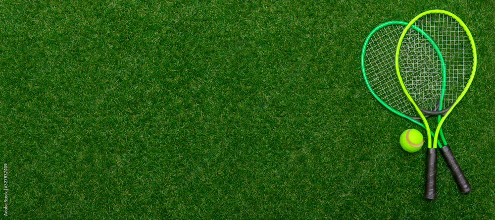 Top view of tennis rackets and ball of green grass. Horizontal sport ...