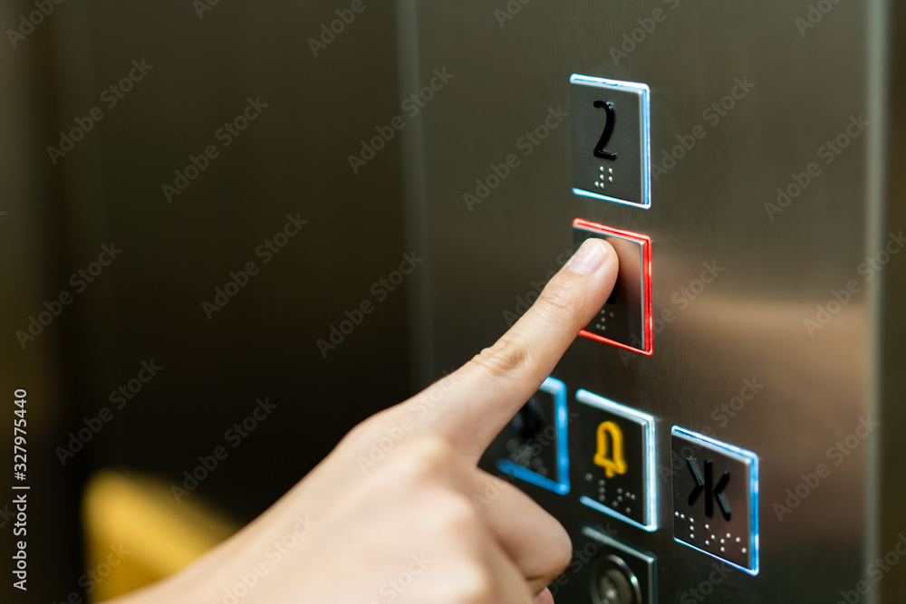 People pressing the button in the lift and select the first floor by ...
