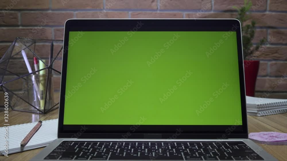 Laptop with green screen on desk in office. Dolly zoom shooting. Loft ...