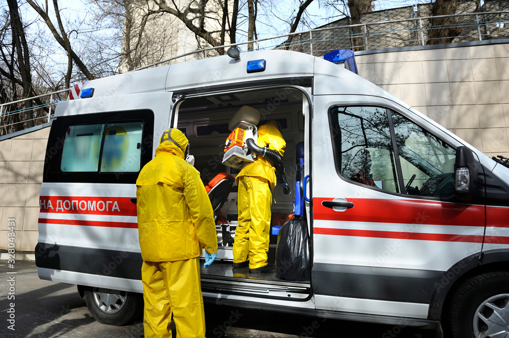 Paramedics disinfecting the ambulance car with the motorized backpack ...