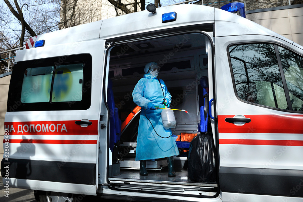 Paramedics disinfecting the ambulance car with the motorized backpack ...