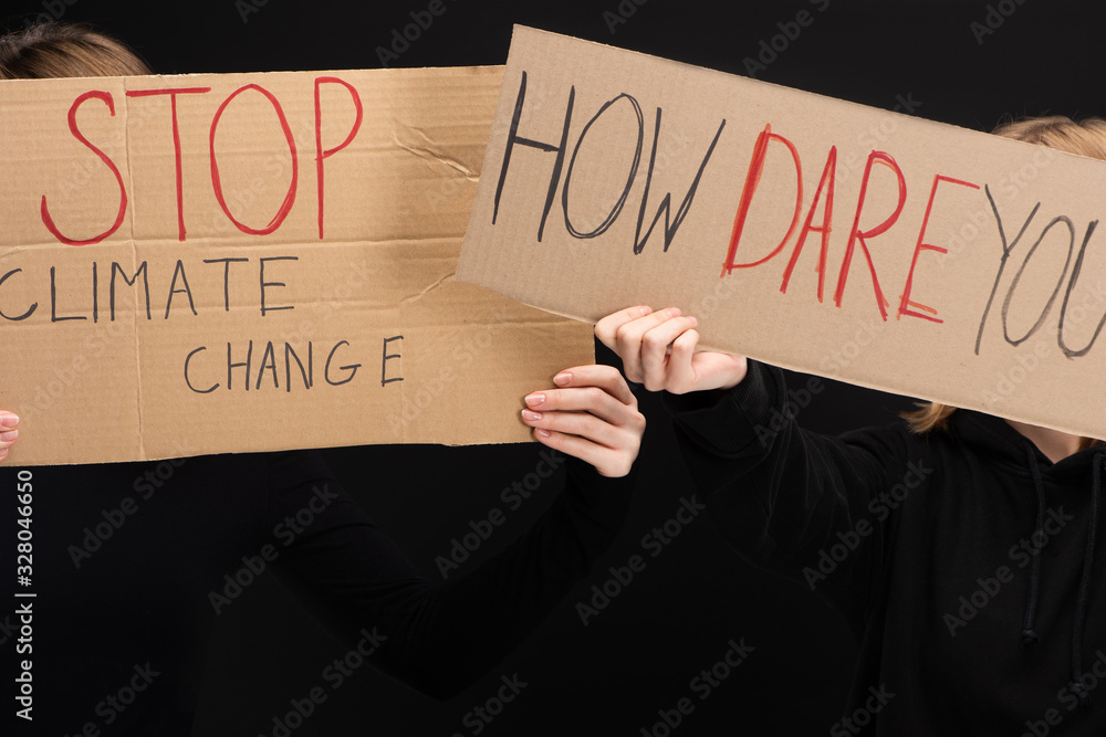 Cropped view of blondes with placards with stop climate change and how ...