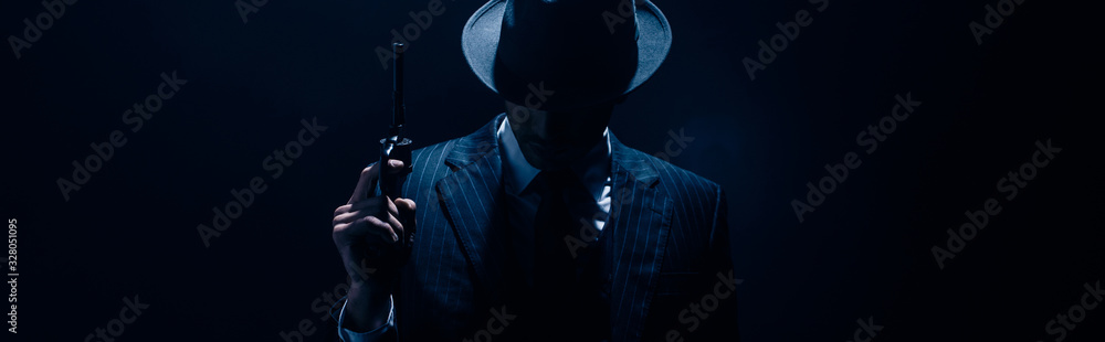Silhouette of gangster raising gun on dark blue background, panoramic ...