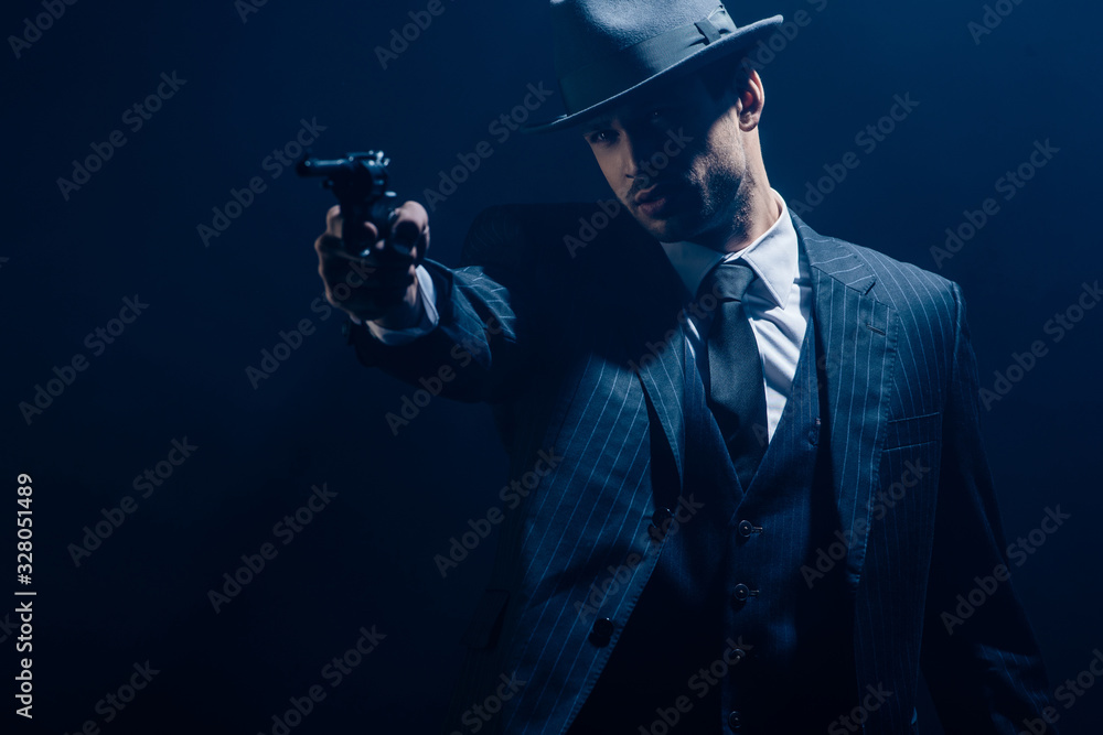 Gangster aiming weapon with outstretched hand on dark background Stock ...