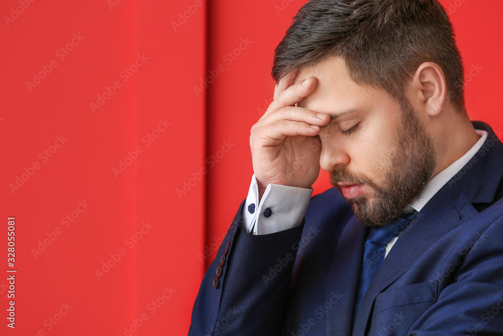 Young worried businessman on color background Stock Photo | Adobe Stock