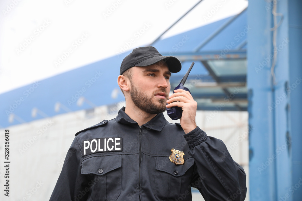 Male police officer patrolling city street Stock Photo | Adobe Stock