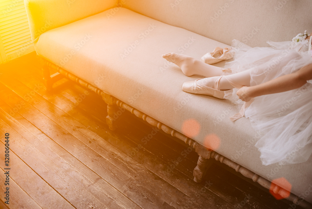 Ballet dancer's feet on studio floor. Teenage dancer puts on ballet ...