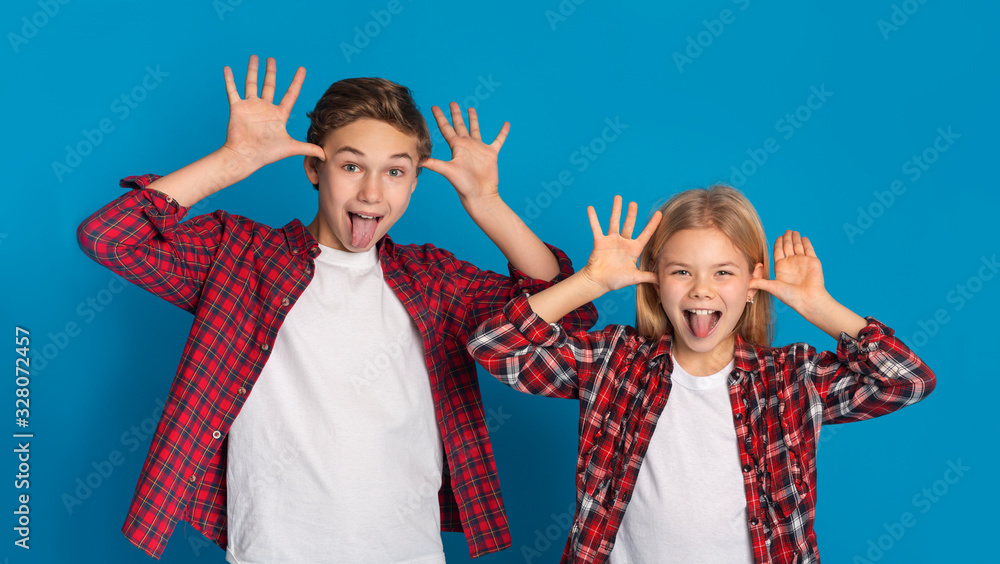 Siblings Fooling. Little brother and sister grimacing at camera, blue ...