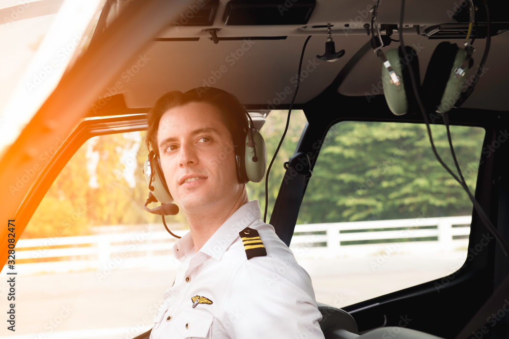 Portrait of young caucasian pilot with headset sitting in private ...