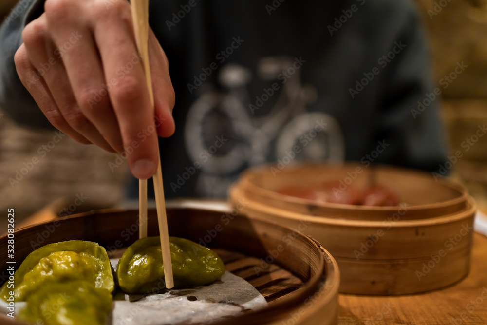 Man eating dim sum, Asian food, using chopsticks. With a beard and a ...
