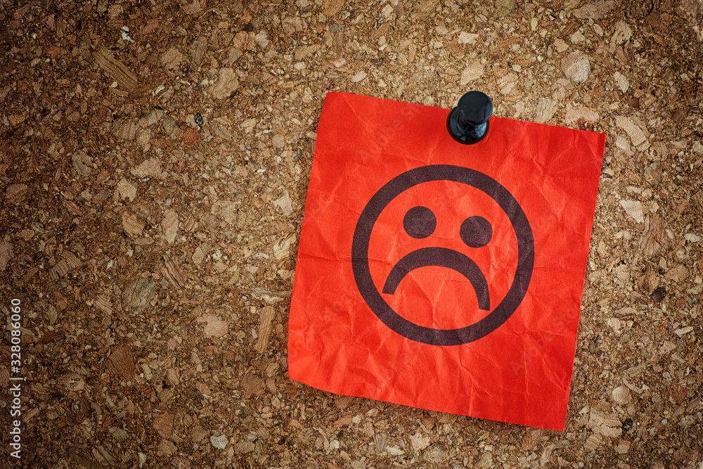 Red paper note with sad face on cork board background Stock Photo ...