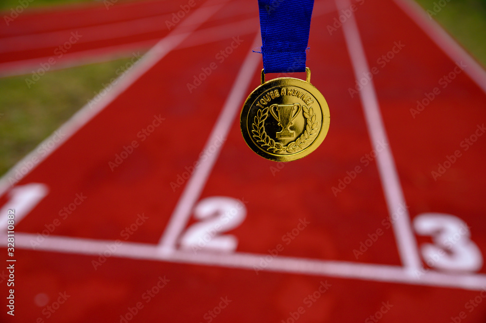 Gold medal, red running track in background, sport motivation concept ...